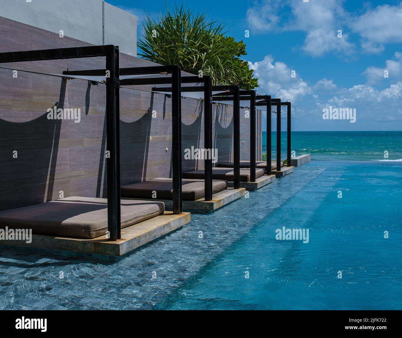Modern Infinity pool at the beach. luxury infinity pool with beach beds ...