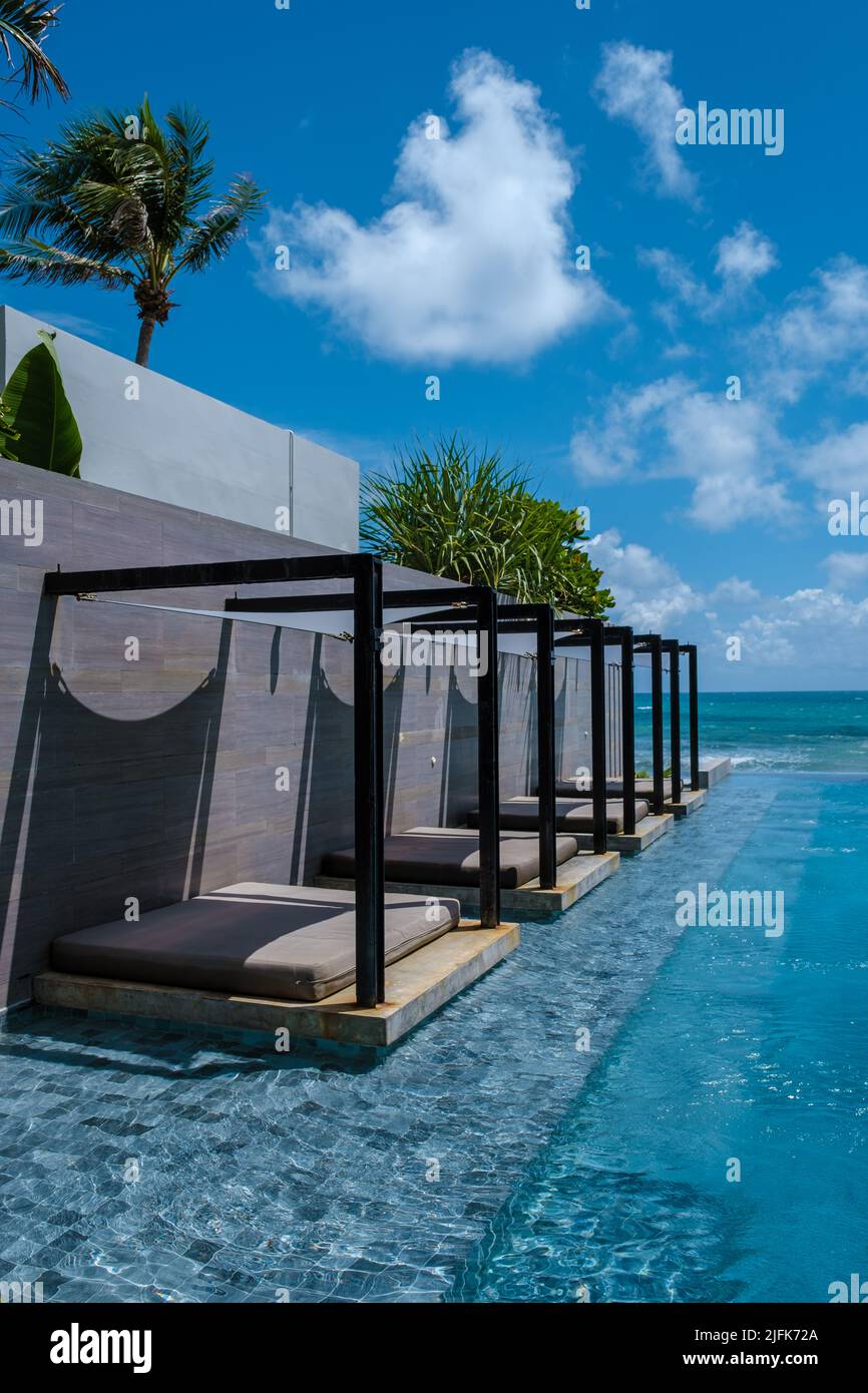 Modern Infinity pool at the beach. luxury infinity pool with beach beds ...