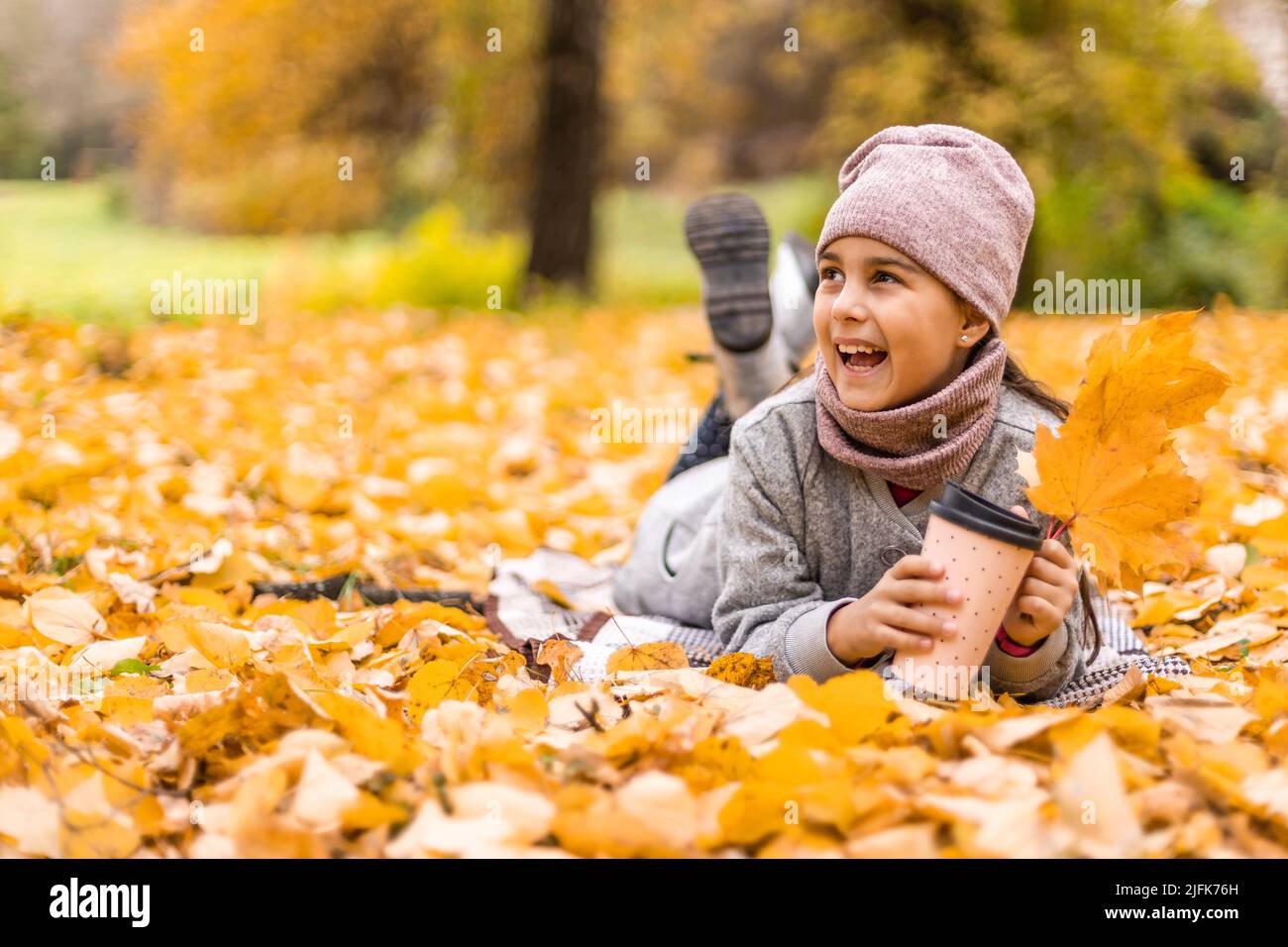 Kids play in autumn park. Children throwing yellow leaves. Child girl ...