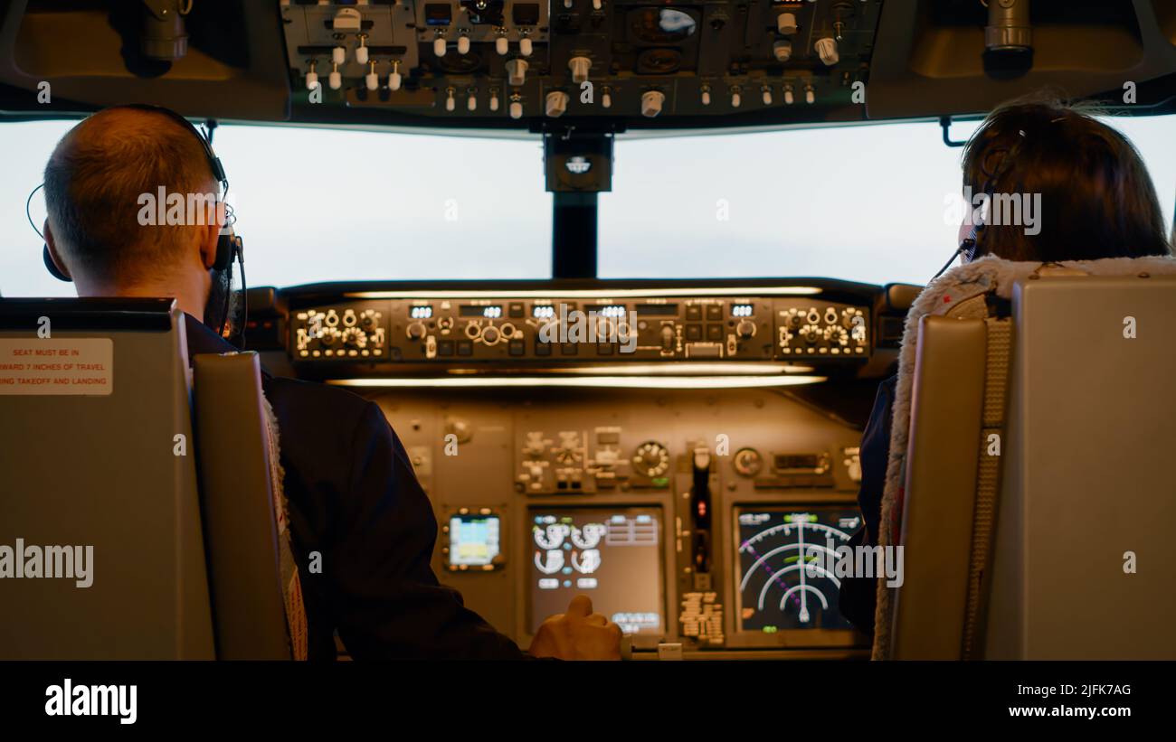 Team of aviators using dashboard buttons to takeoff with plane ...