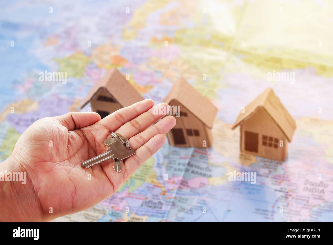 Selective focus - Human hand holding key of paper house toy or ...