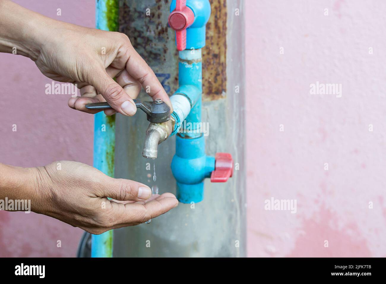 Closed up metal water faucet which is closed by right hand.Water ...