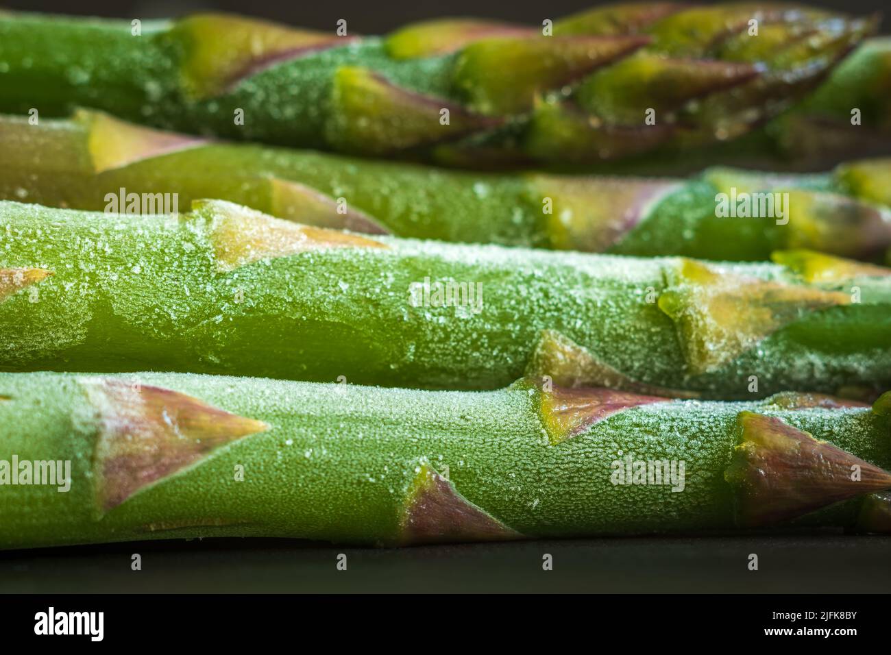 Frozen asparagus stems on dark background closeup Stock Photo - Alamy