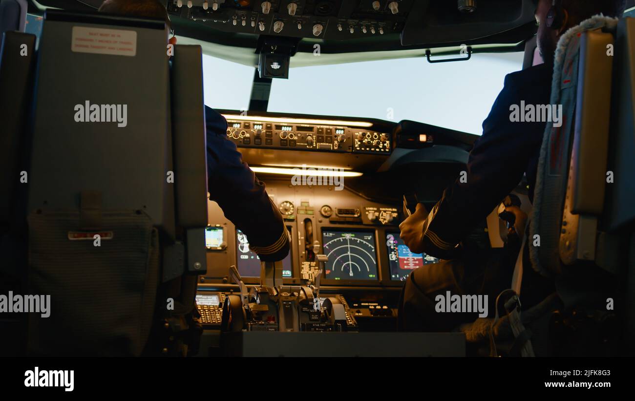 Diverse team of aviators throttling engine lever to takeoff, using ...