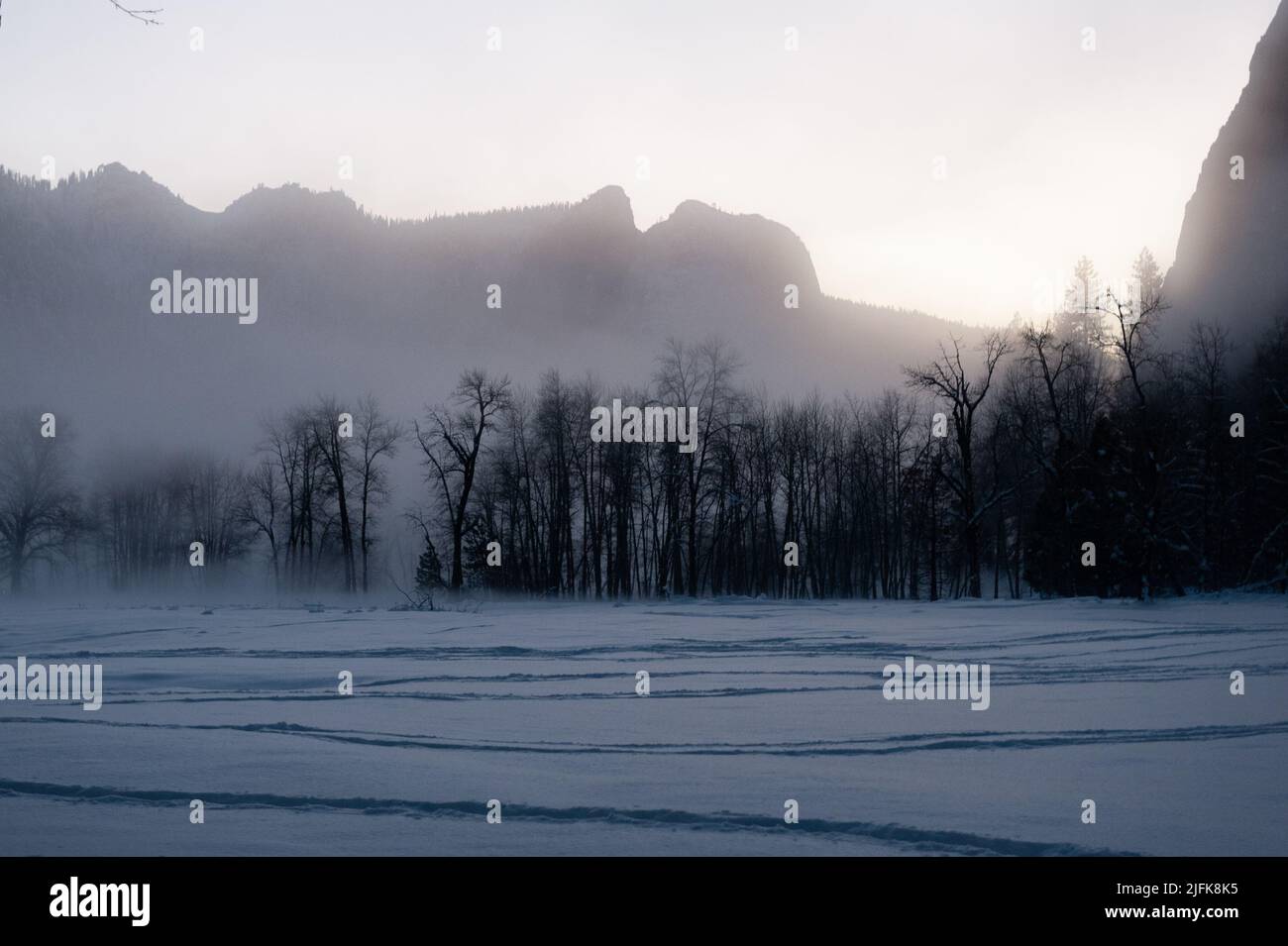 An eerie mist covers the floor of yosemite valley, while a thin layer ...