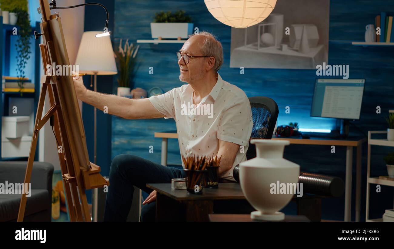 Old artist using pencils to draw professional masterpiece on canvas ...