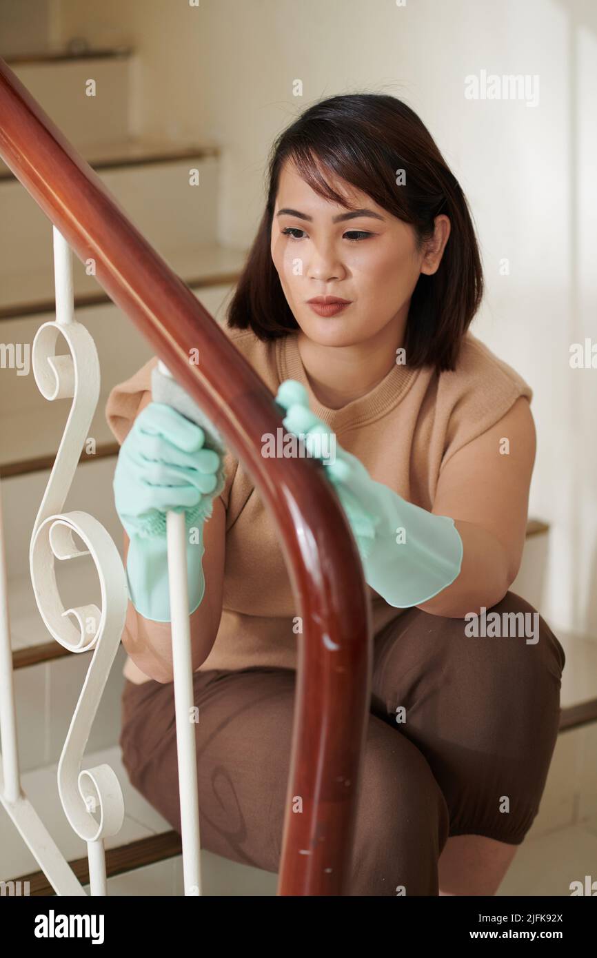 Asian housekeeper in gloves doing wet cleaning at home, she wiping ...