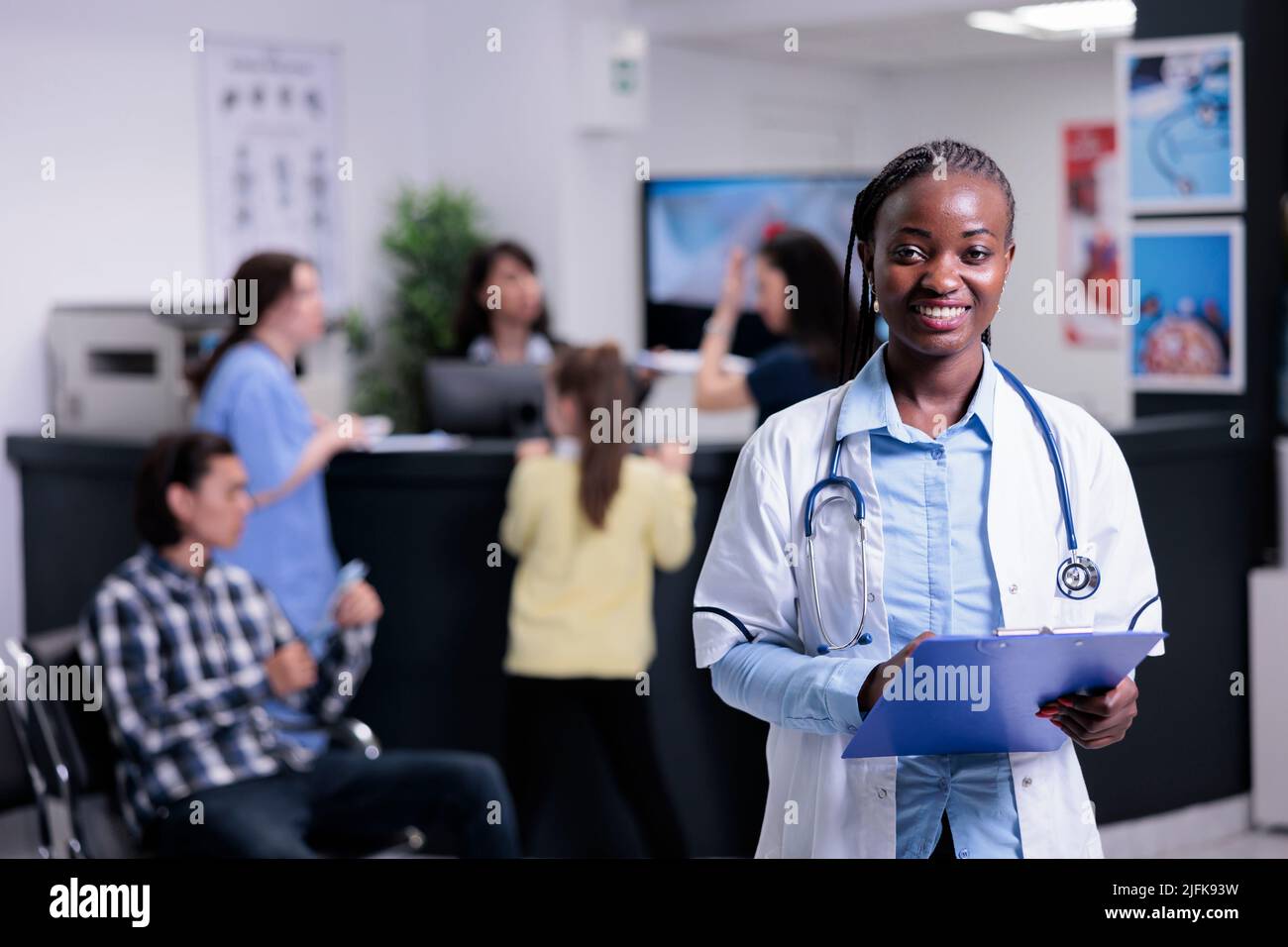 Portrait of smiling confident doctor in busy private hospital waiting ...