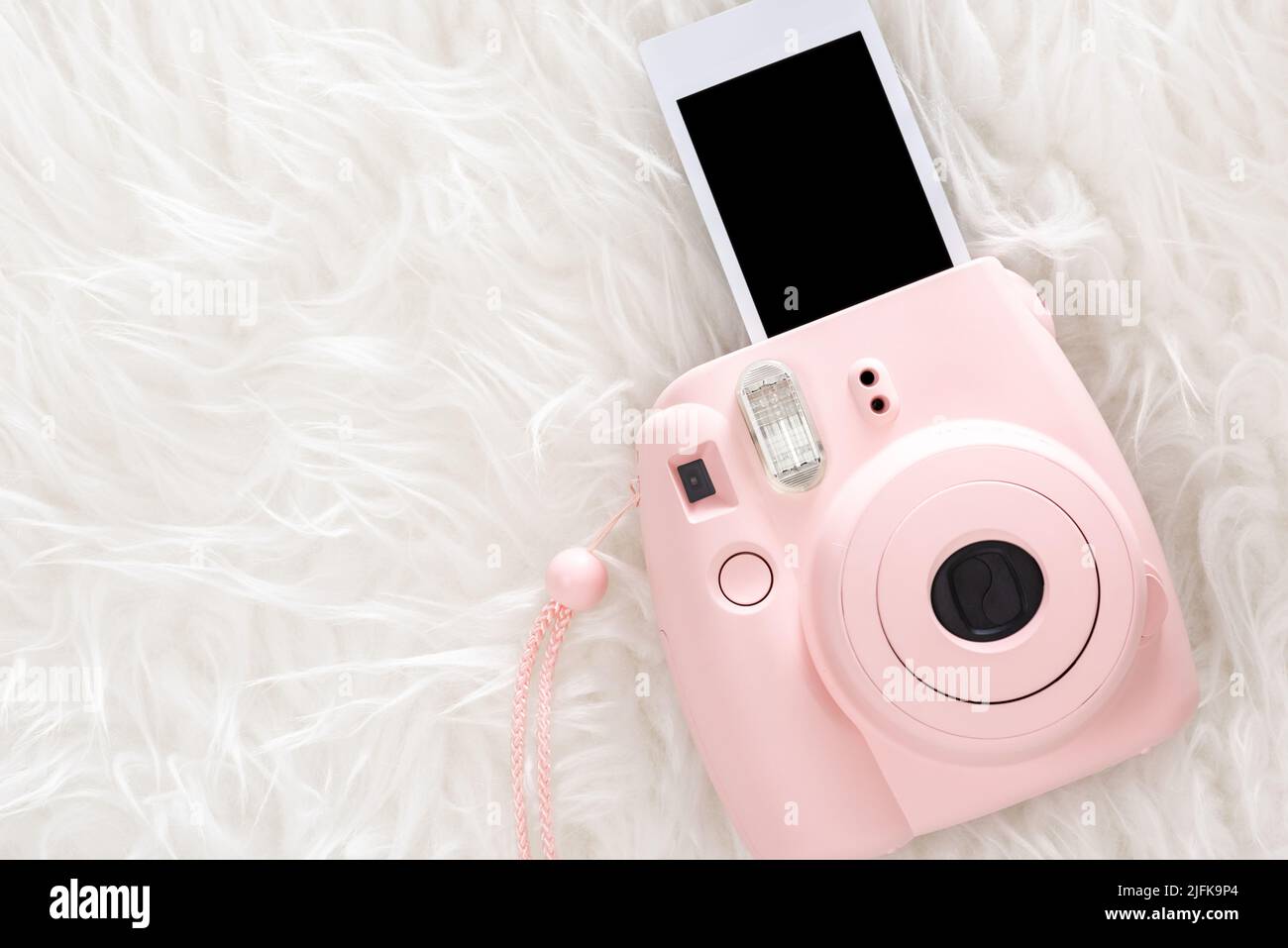 The pink instant camera with blank instant films over white background ...