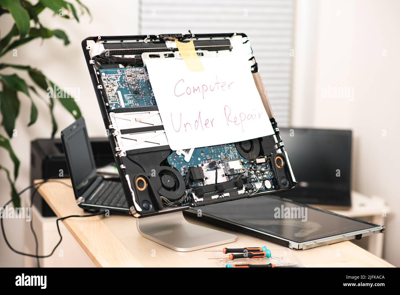 Broken computer with note "Computer Under Repair". Computer service and ...