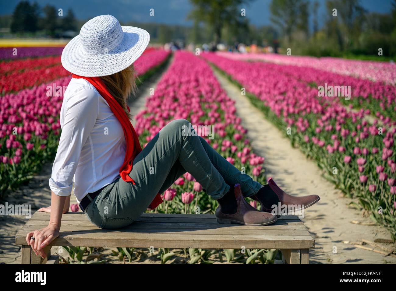 Well Dressed Middle Aged Woman Wearing White Straw Hat Sitting On A