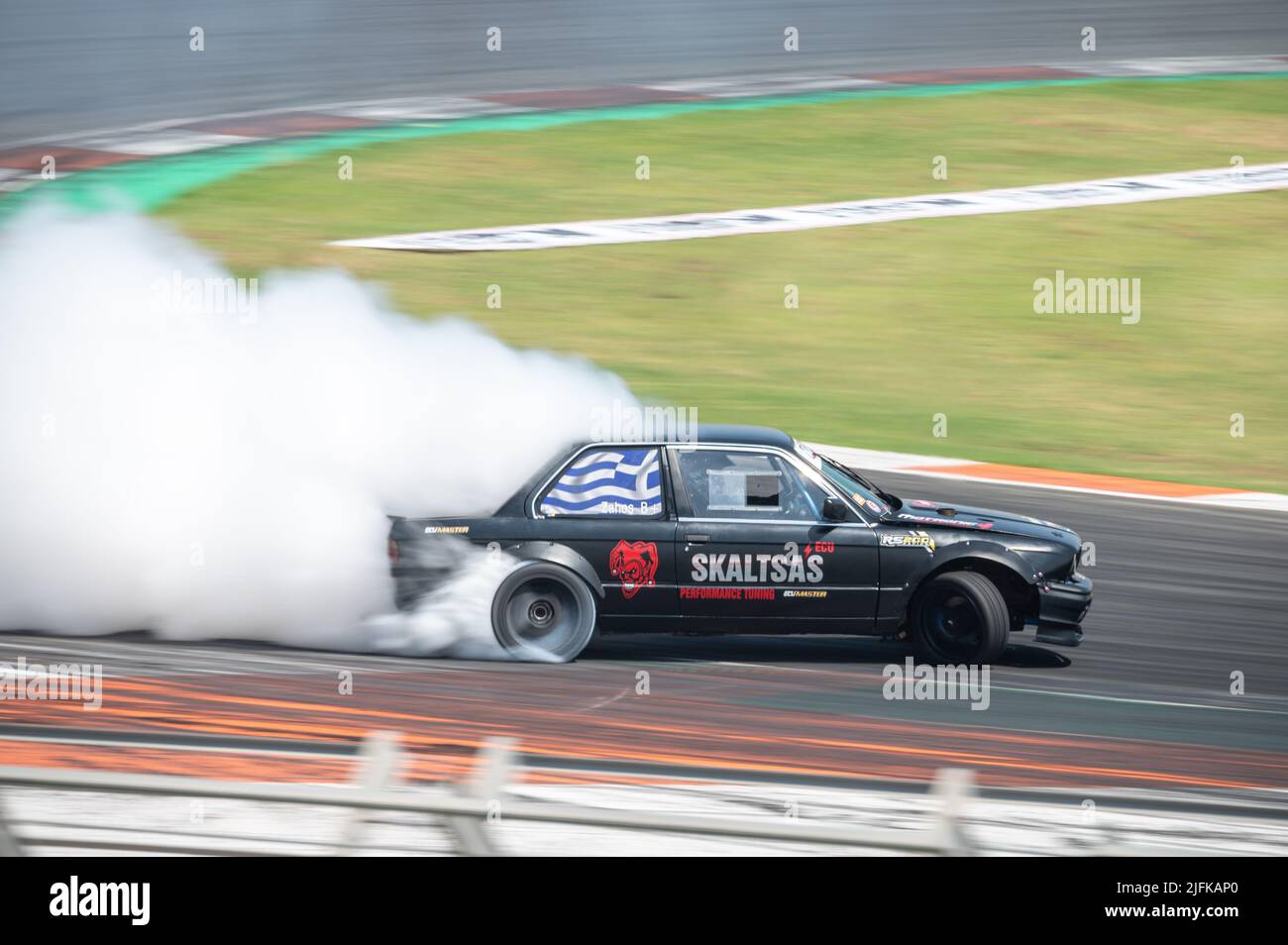 black BMW E30 skidding in the battles on the Valencia racing circuit ...