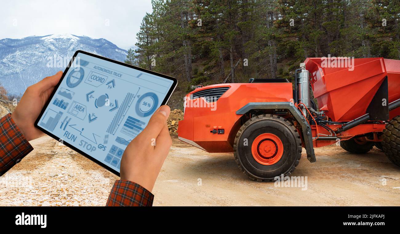 Engineer programs autonomous mining truck using digital tablet Stock ...