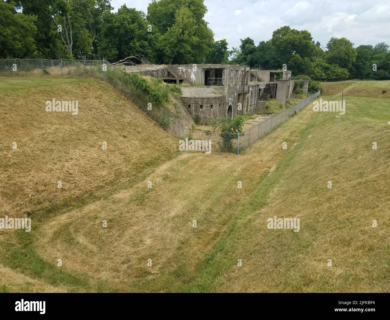 large depression or valley in green grass outdoor and abandoned cement ...