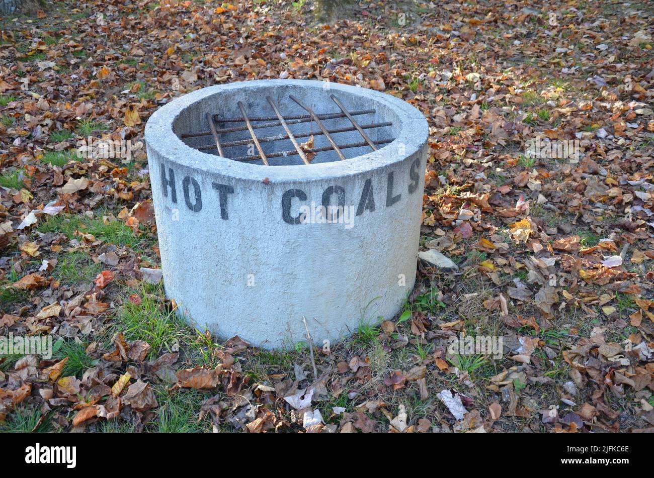 cement hot coal fire pit with metal grate and leaves Stock Photo - Alamy