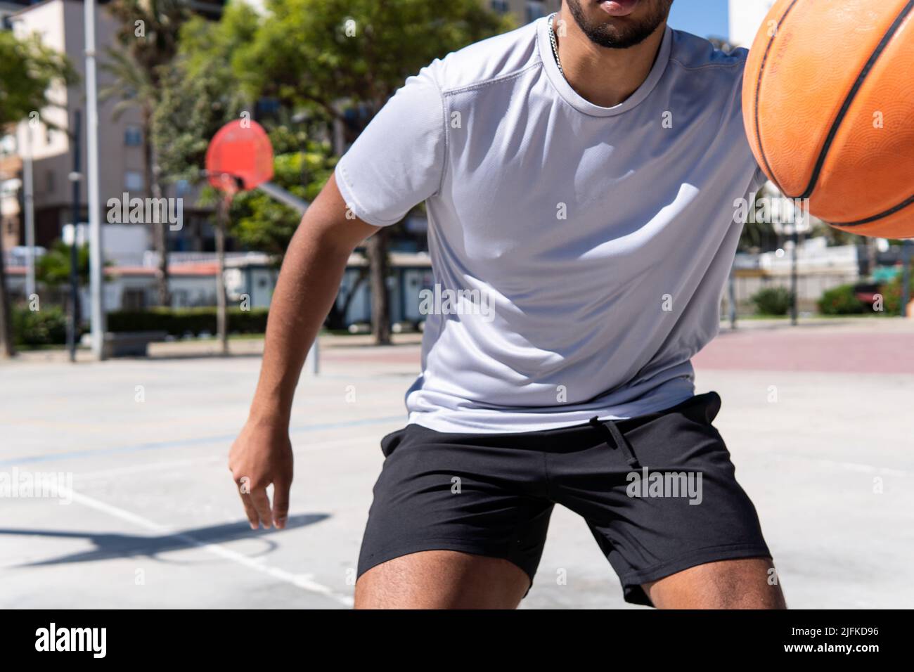 Close up view of an unrecognizable young muslim man playing basketball ...