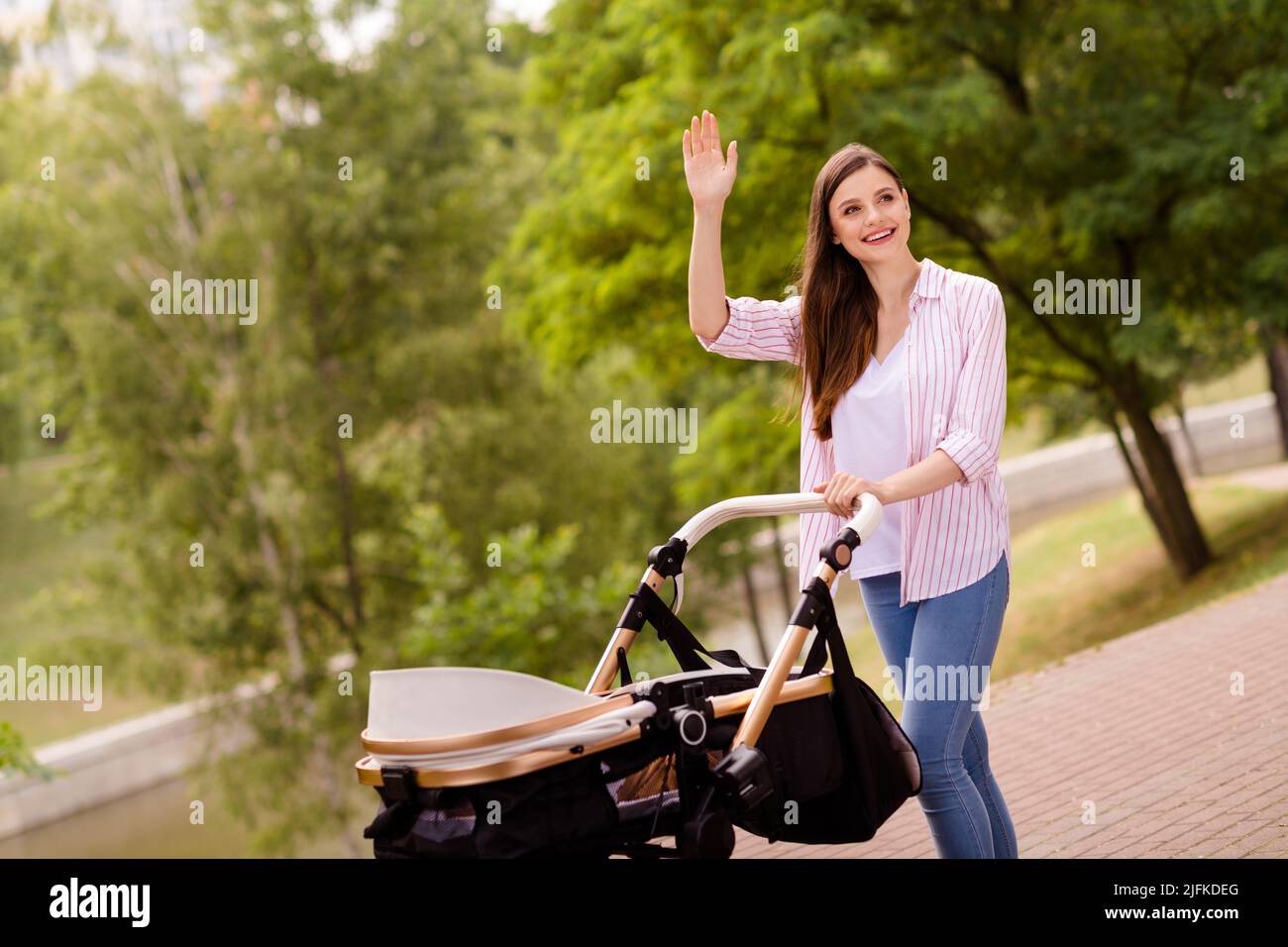 Photo of shiny excited mother dressed casual clothes walking buggy ...