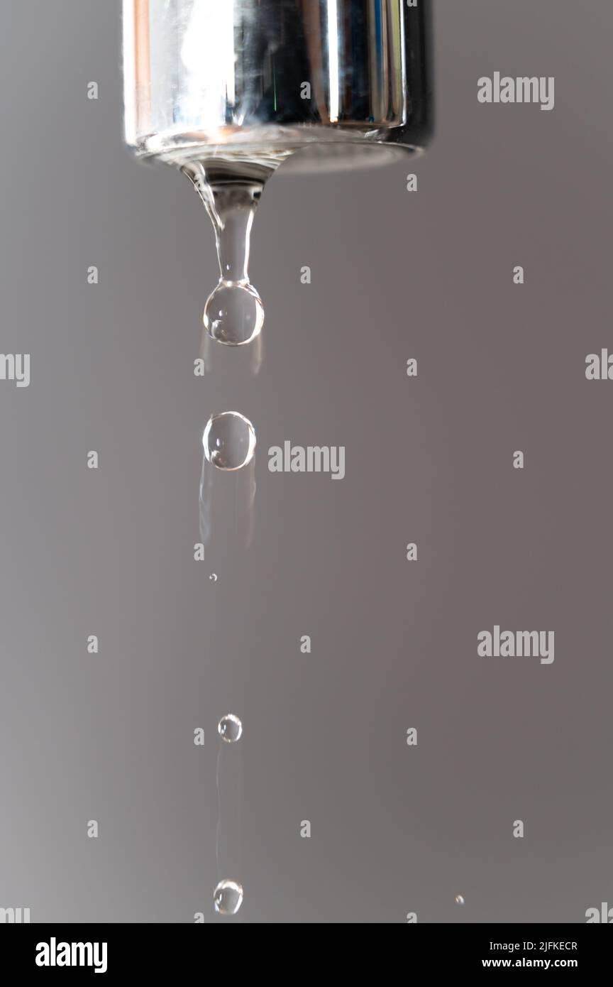 Tap from which drops of water flow. Drought, shortage, rationing and ...