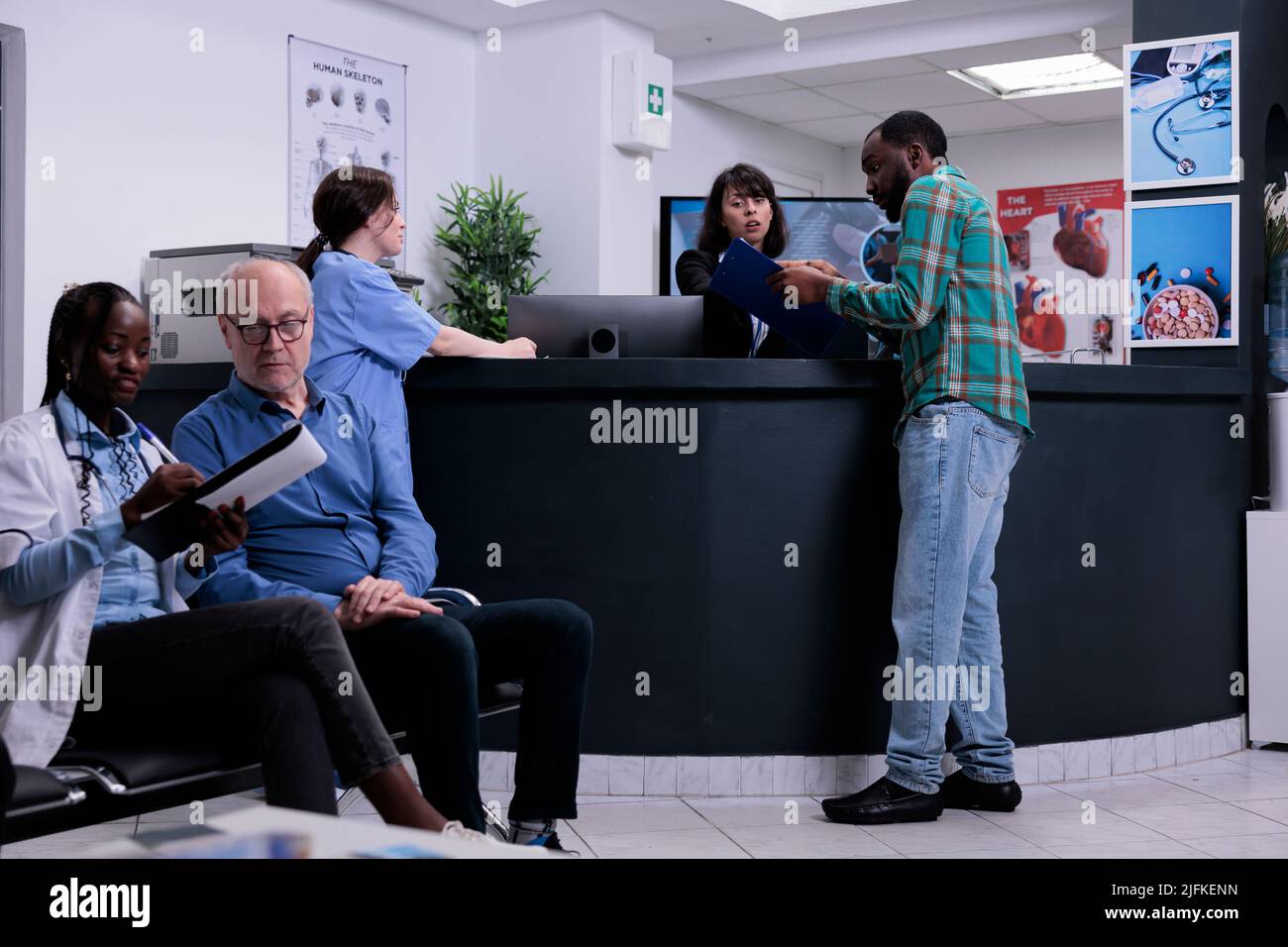 African american patient giving clipboard with completed form to ...