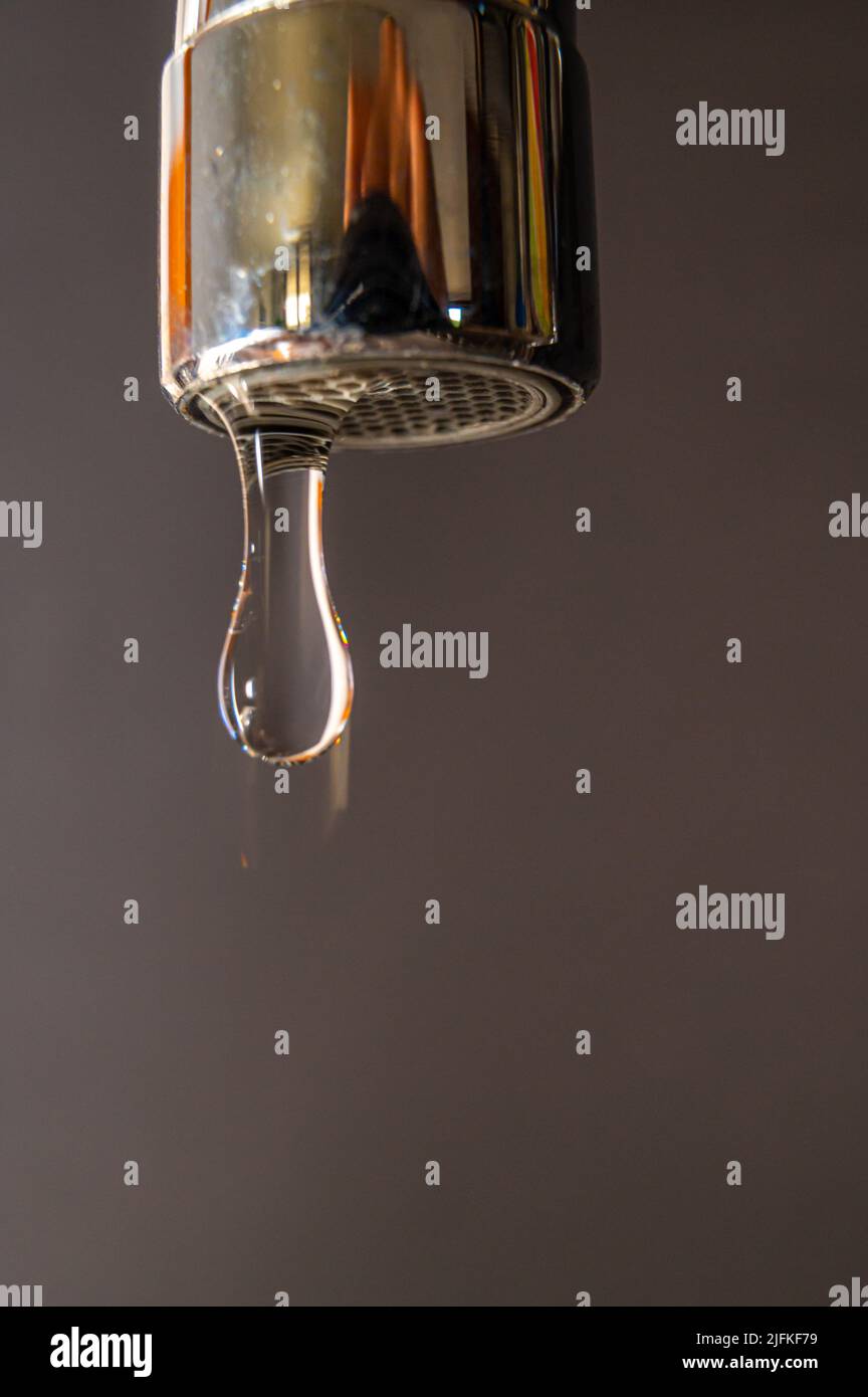 Tap from which drops of water flow. Drought, shortage, rationing and ...