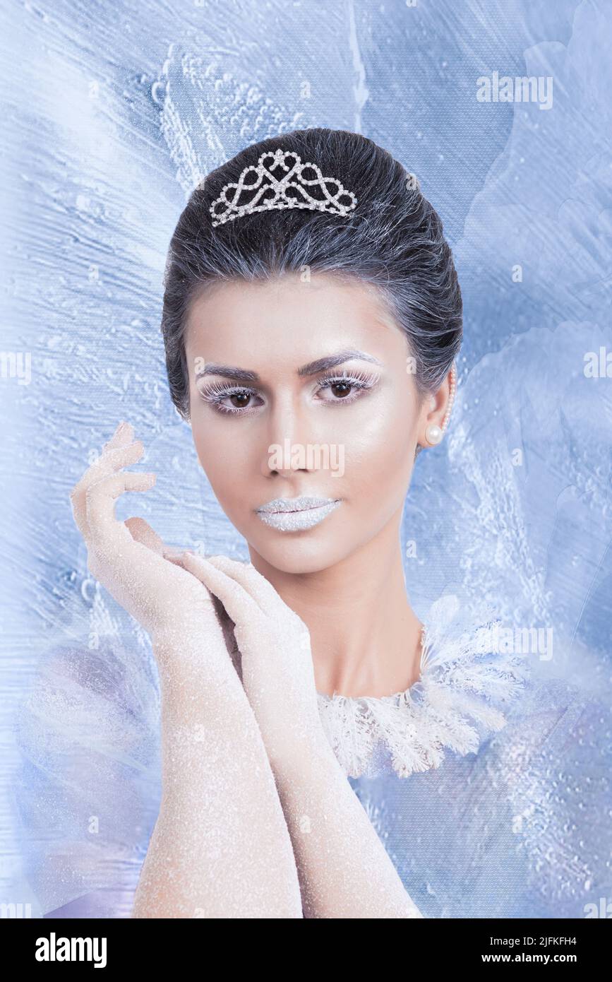 Beautiful snow queen concept with a delicate look on frozen background ...