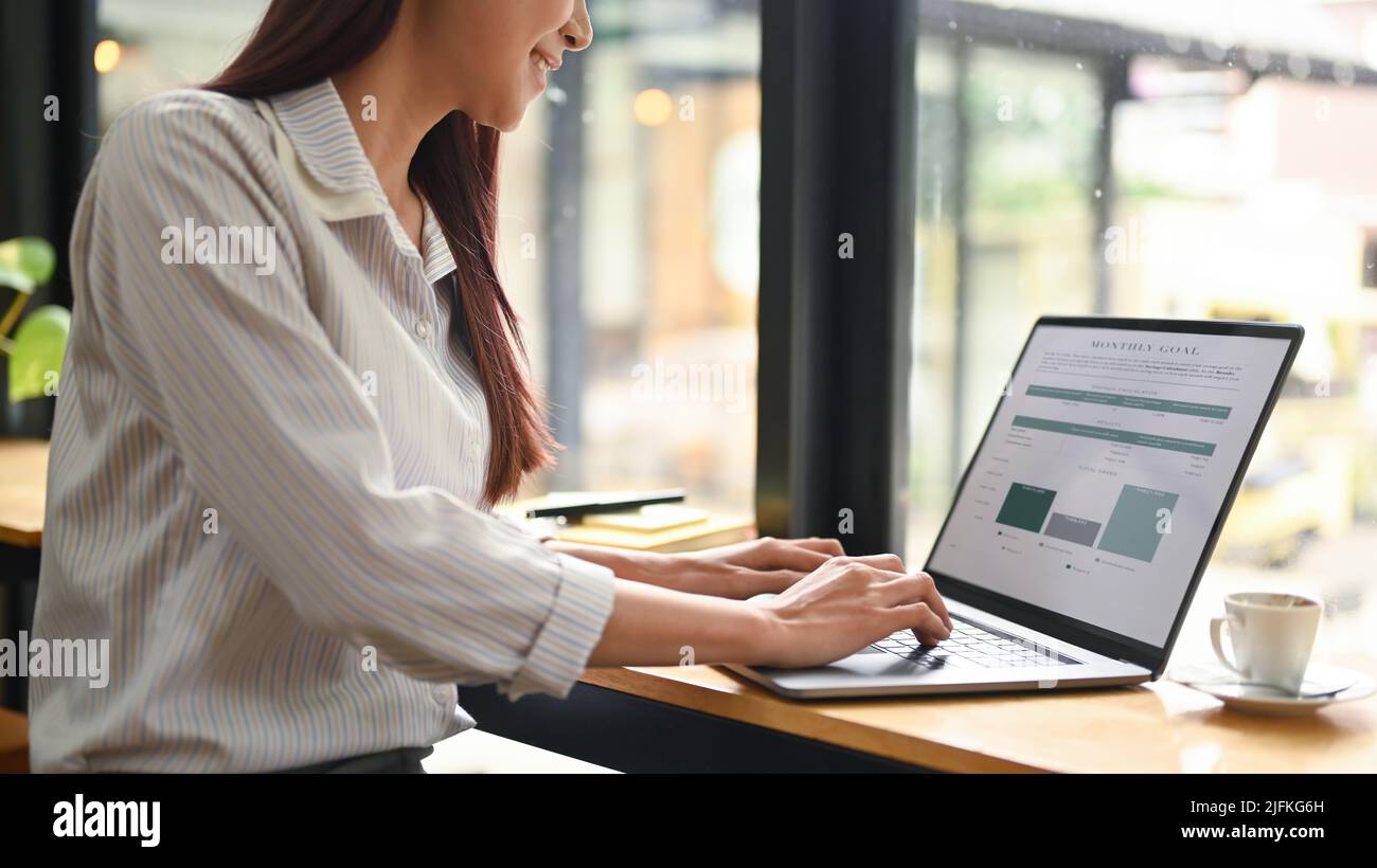 Young female investor analyzing stock charts on laptop screen, working ...