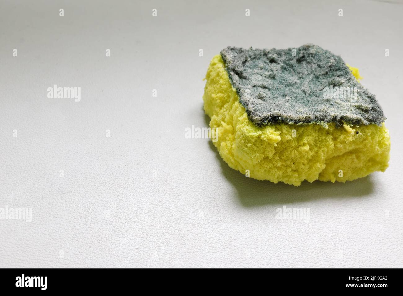 Selective focus of torn, worn out and dirty dishwashing kitchen sponge ...