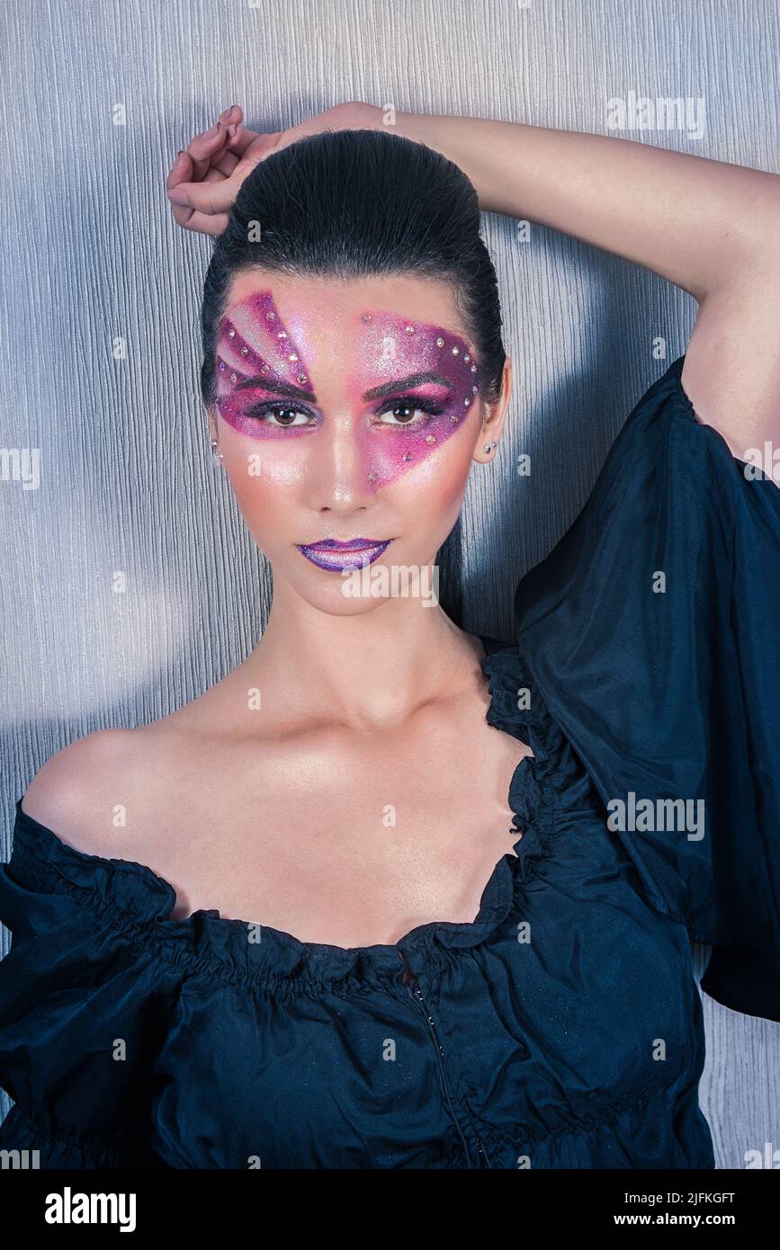 Beautiful Caucasian woman with purple face painting and crystals on her ...