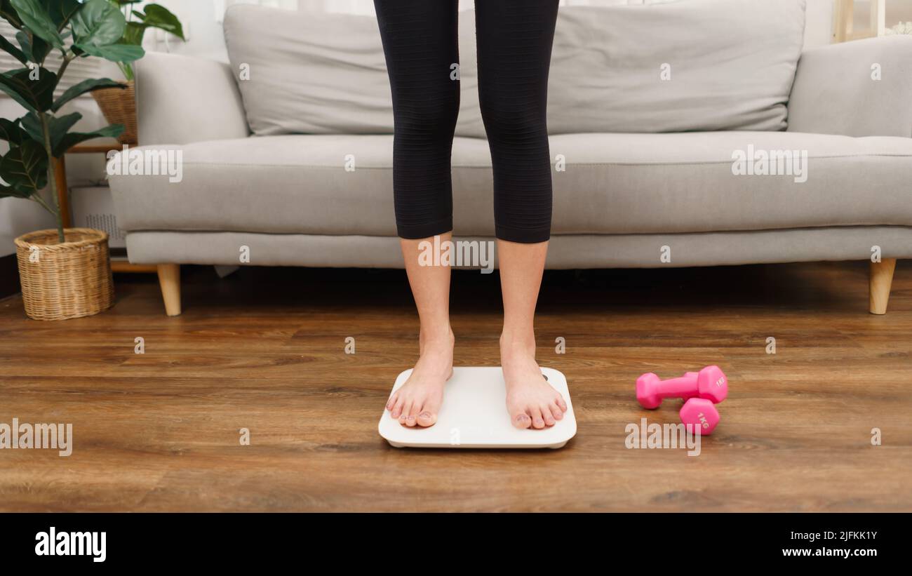 Healthy and weight loss concept, Young Asian woman stand on weighing ...