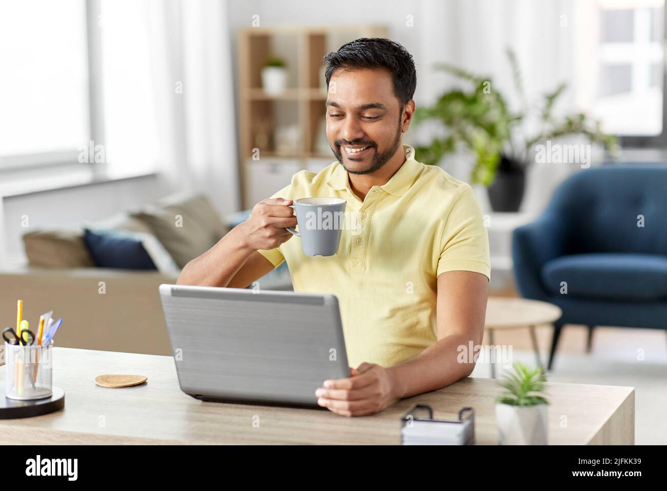 man with laptop drinking coffee at home office Stock Photo - Alamy