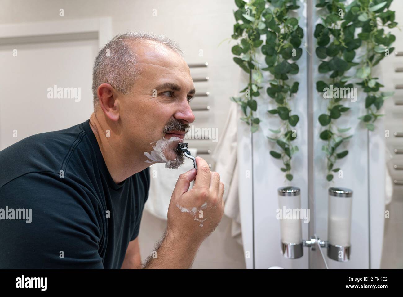 Man shaving with razor using foam in bathroom in the morning Stock ...