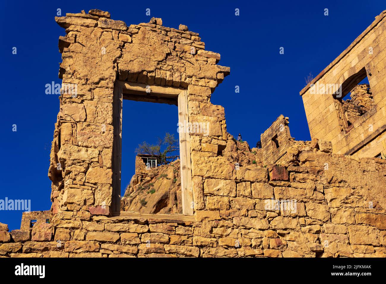 ruins of a wall with the sky in an empty window opening in the ...