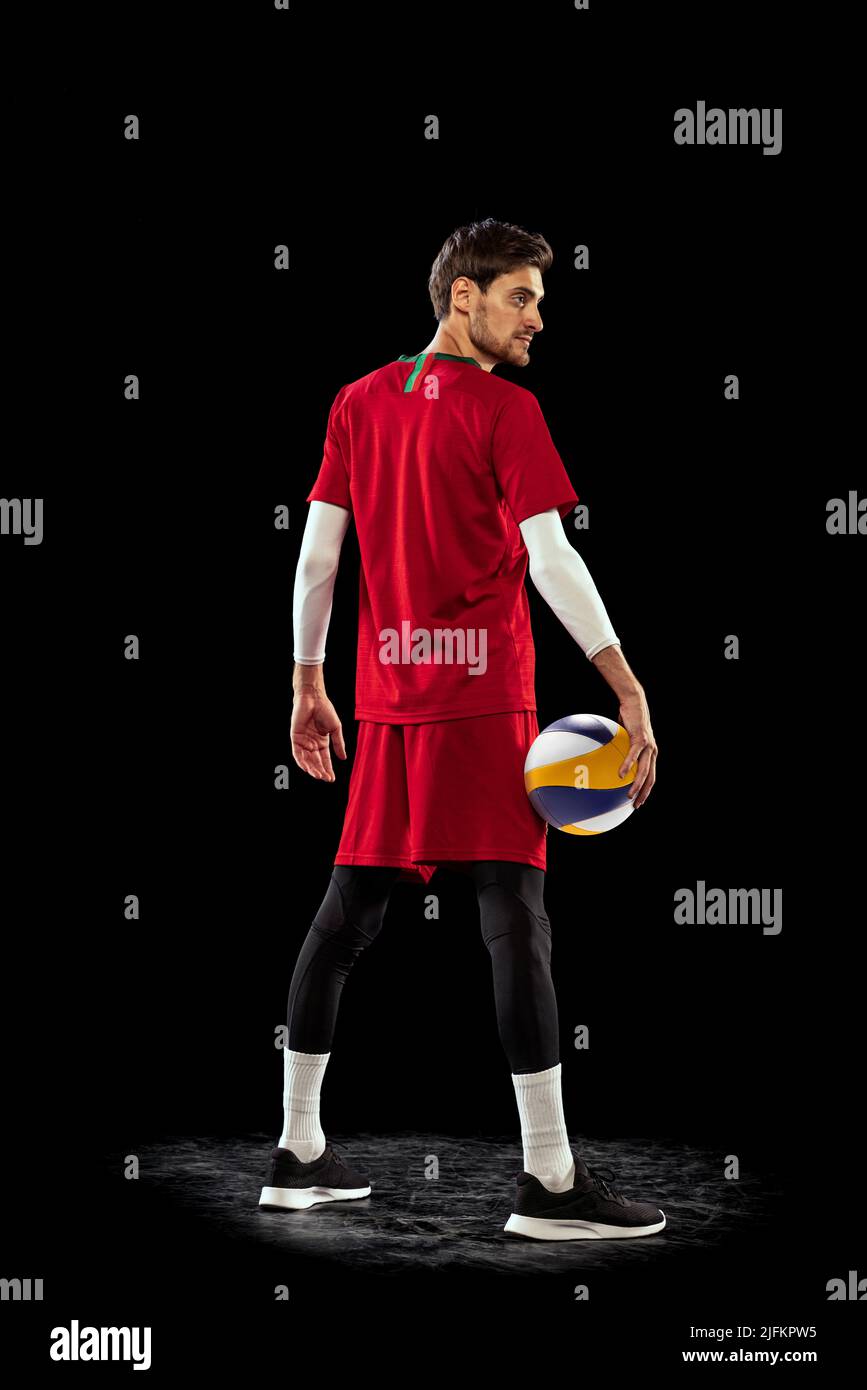 Portrait of young man, volleyball player posing in uniform isolated ...
