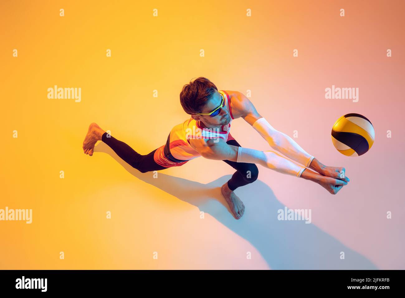 Portrait of young man, volleyball player in motion, training, bumping ...