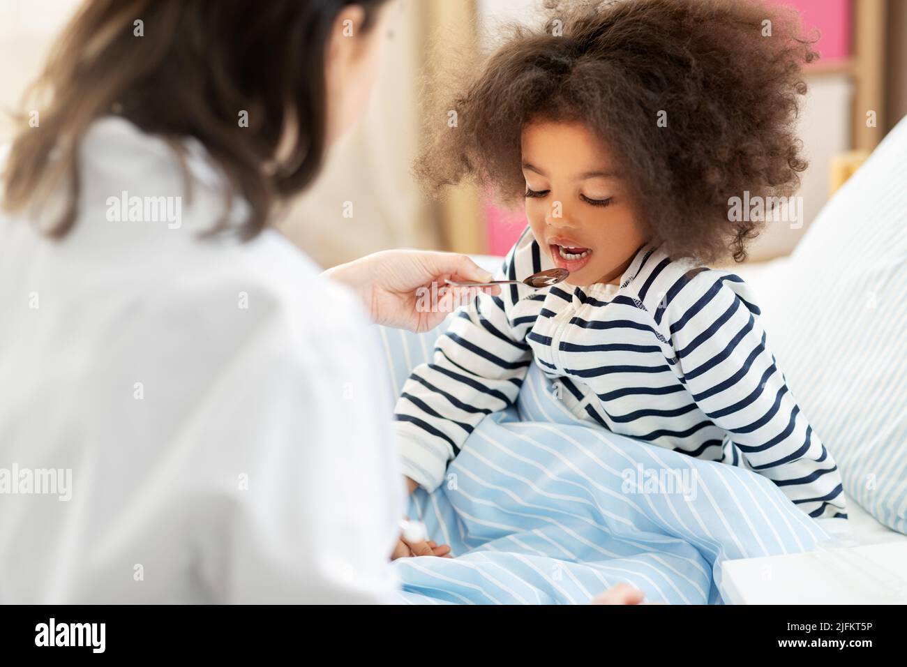 doctor giving medicine to sick girl in bed at home Stock Photo - Alamy