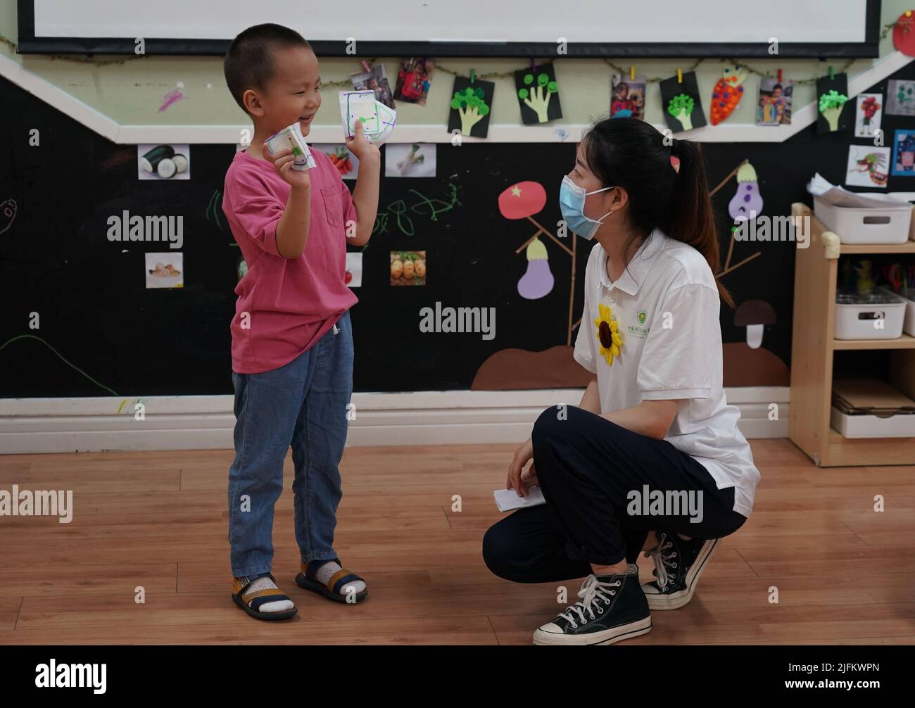 Beijing, China. 4th July, 2022. A child interacts with his teacher as a ...