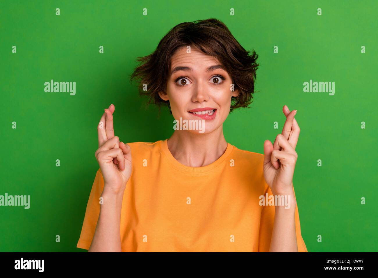 Photo of sweet doubtful young lady wear orange outfit biting lips ...