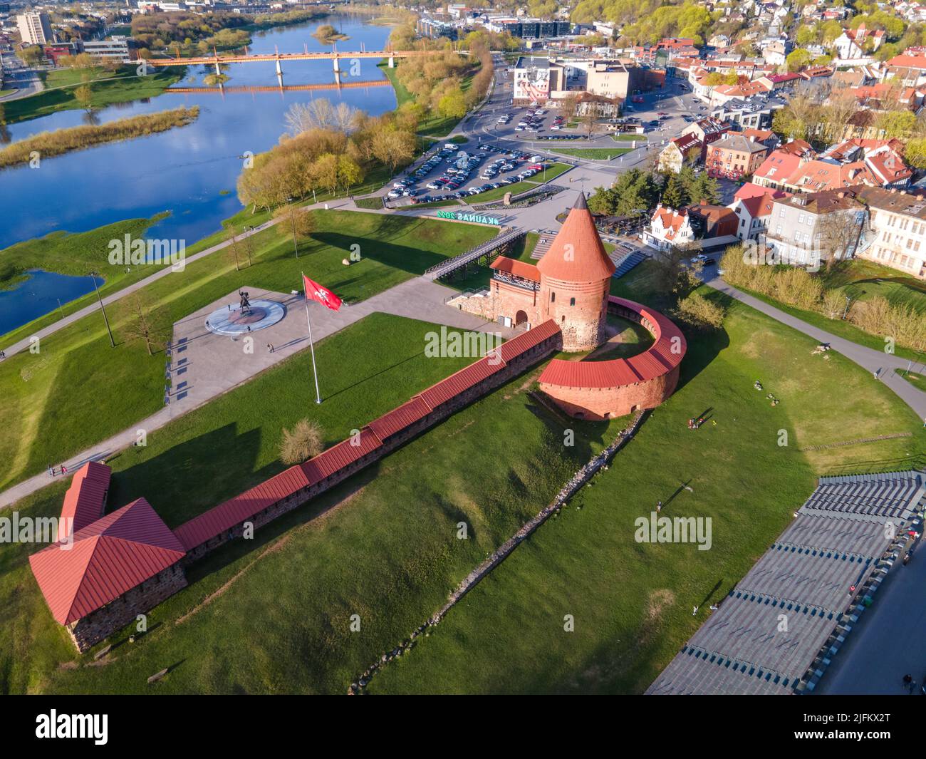 A Kaunas castle red flag in front with a large bridge over a river on ...