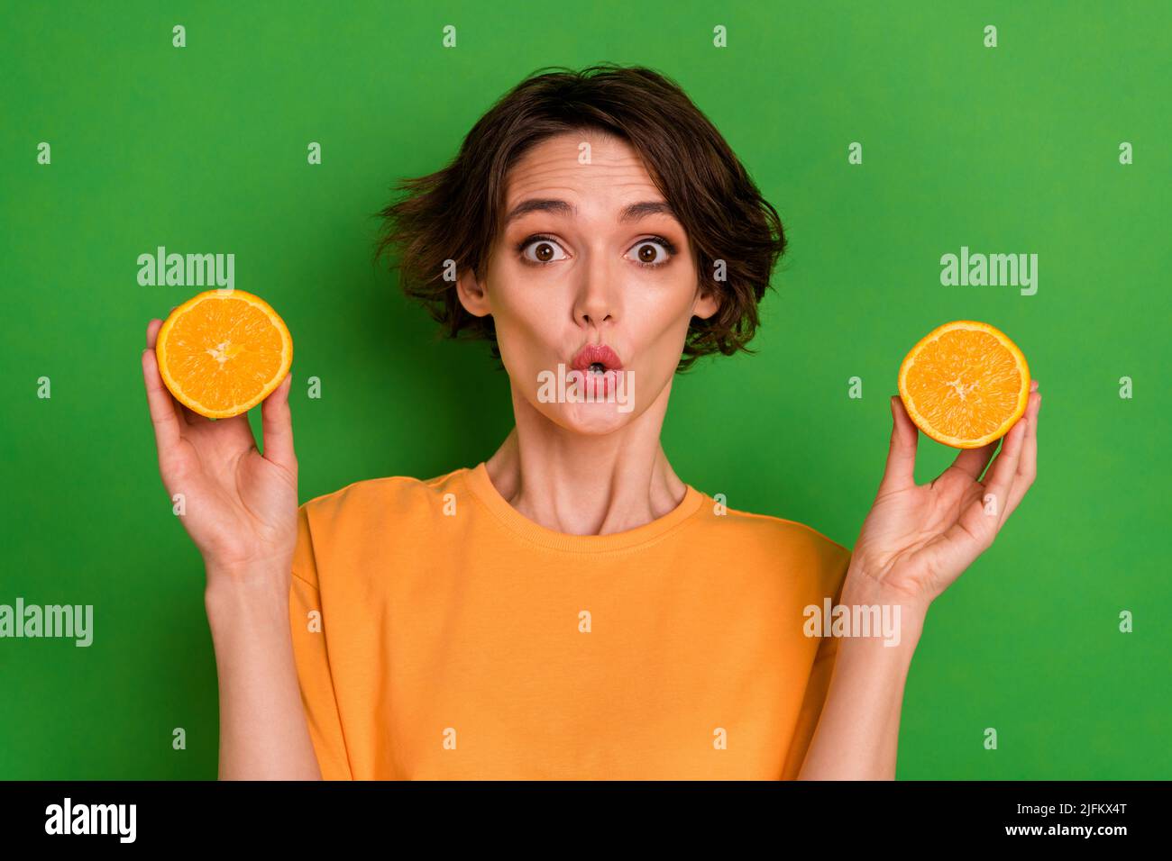 Photo of impressed funky young lady wear orange outfit holding citrus ...