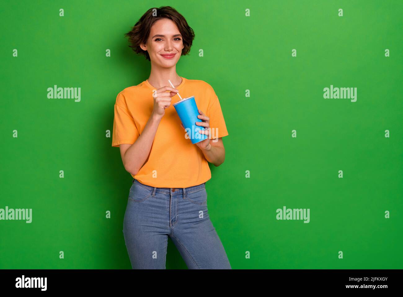 Photo of funky sweet young lady wear orange outfit drinking soda empty ...