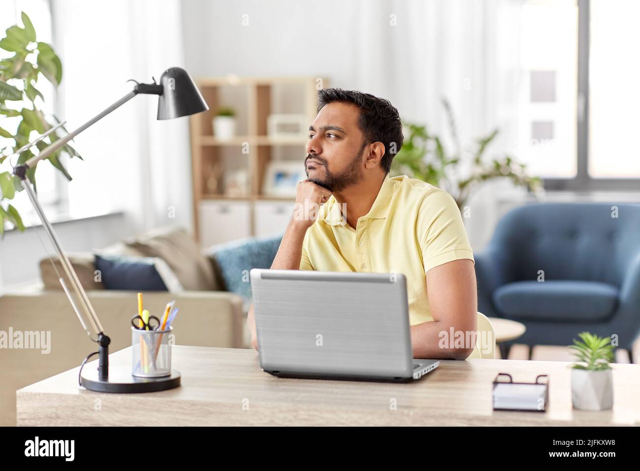 indian man with laptop thinking at home office Stock Photo - Alamy