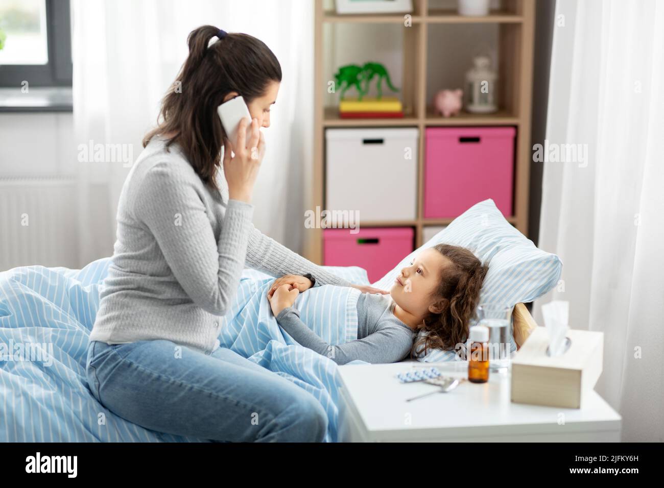 ill daughter and mother calling on phone at home Stock Photo - Alamy
