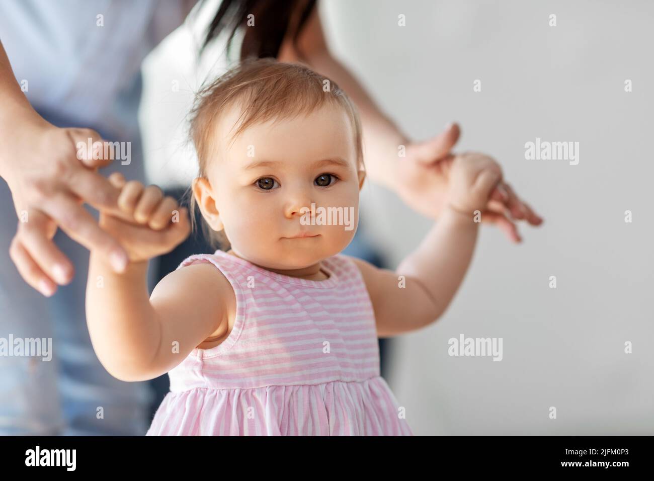 baby girl learning to walk with mother's help Stock Photo - Alamy