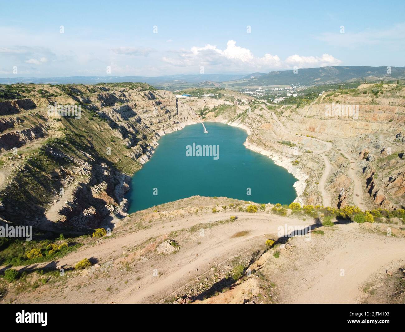 Aerial top view on opencast mining quarry with flooded bottom ...