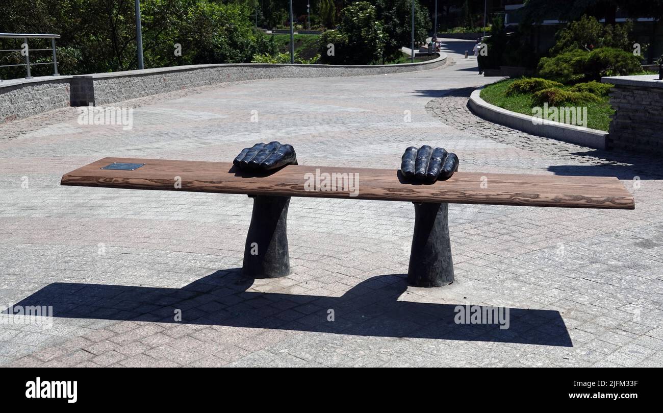 Kiev, Ukraine June 16, 2021: Monument ART bench hands hold a board in ...