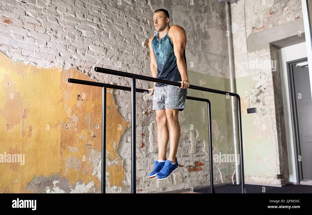 man doing triceps dip on parallel bars in gym Stock Photo - Alamy