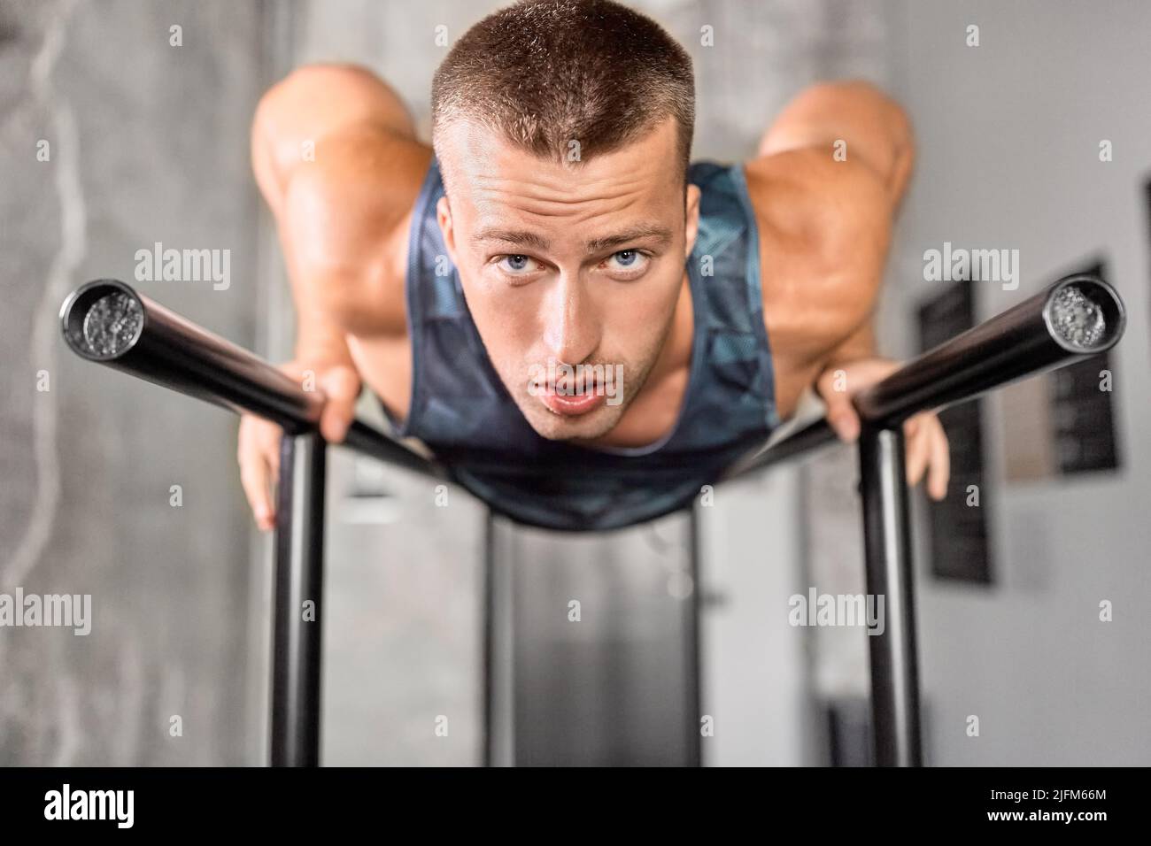 man doing push-ups on parallel bars in gym Stock Photo - Alamy
