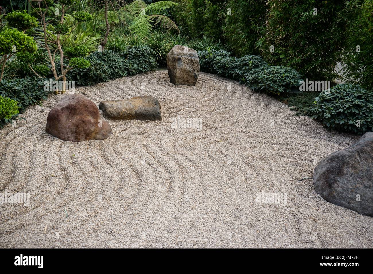 A scenic view of a Zen garden with sandy ground and rocks surrounded by ...