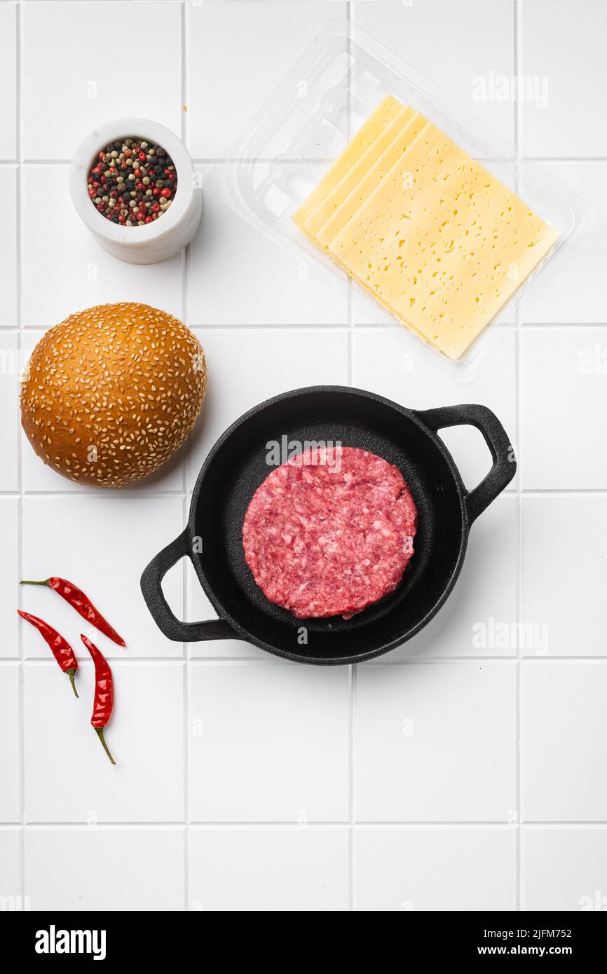 Burger patty on white ceramic squared tile table background, top view ...