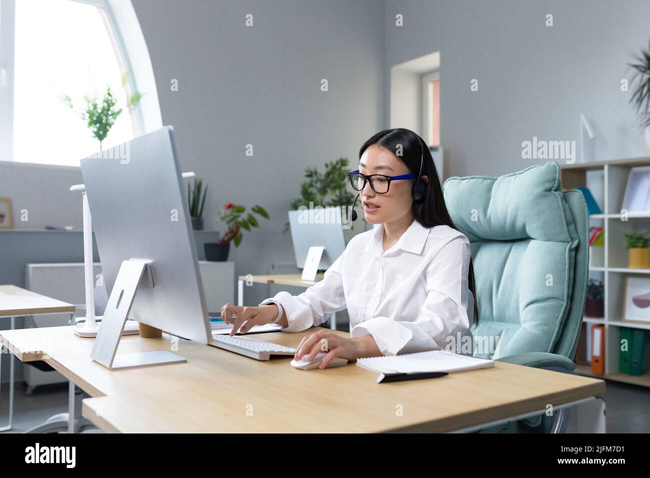 Asian successful business woman working with computer in modern office ...